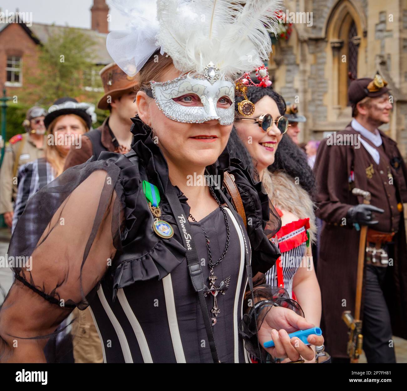 A masked female steampunk is part of a procession at a steampunk event ...