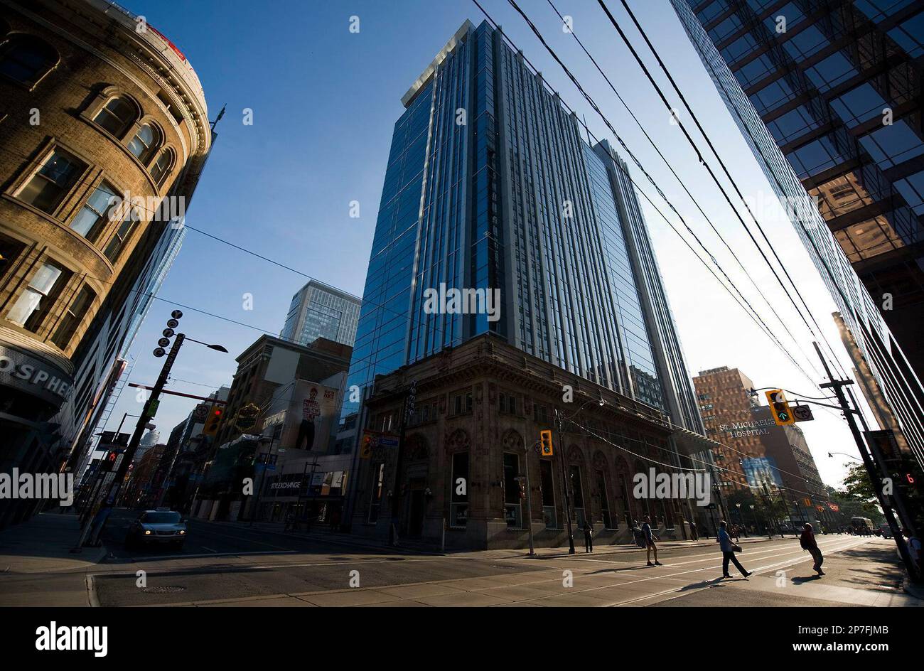 Pedestrians cross the street at the intersection of Yonge and Queen ...
