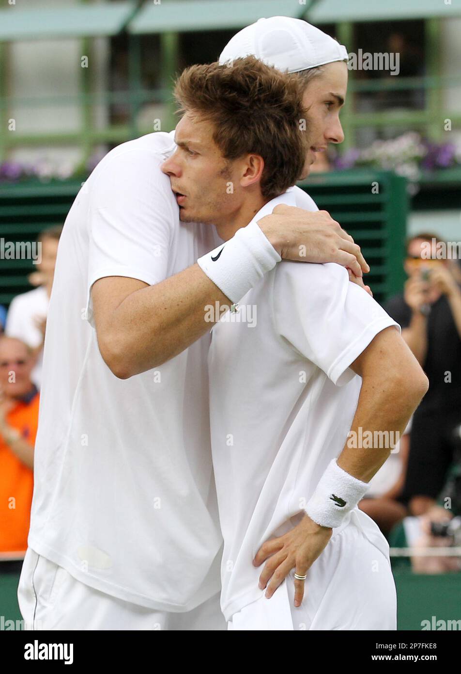 John Isner, right, of the US embraces his opponent France's Nicolas ...
