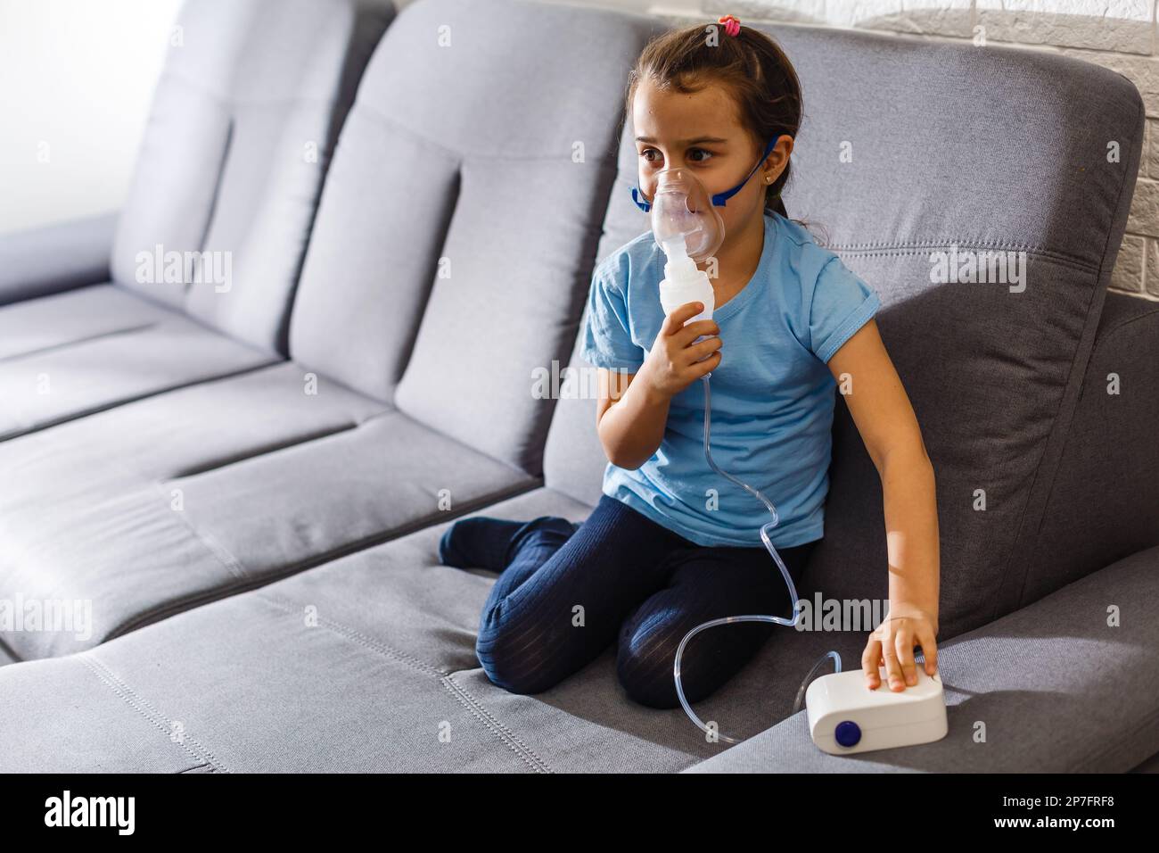 Little girl making inhalation with nebulizer at home. child asthma ...