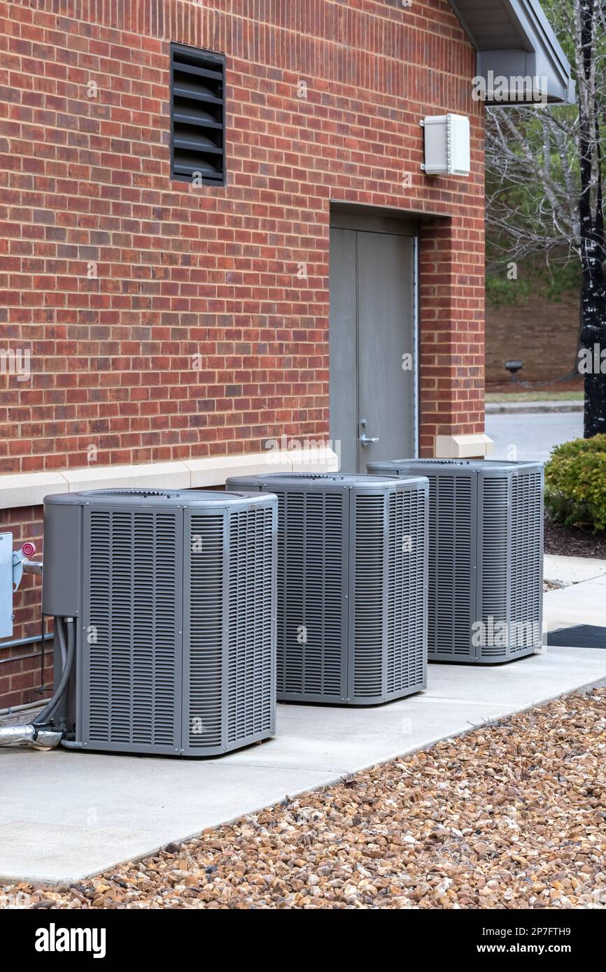Vertical shot of commercial air conditioners outside a brick building ...