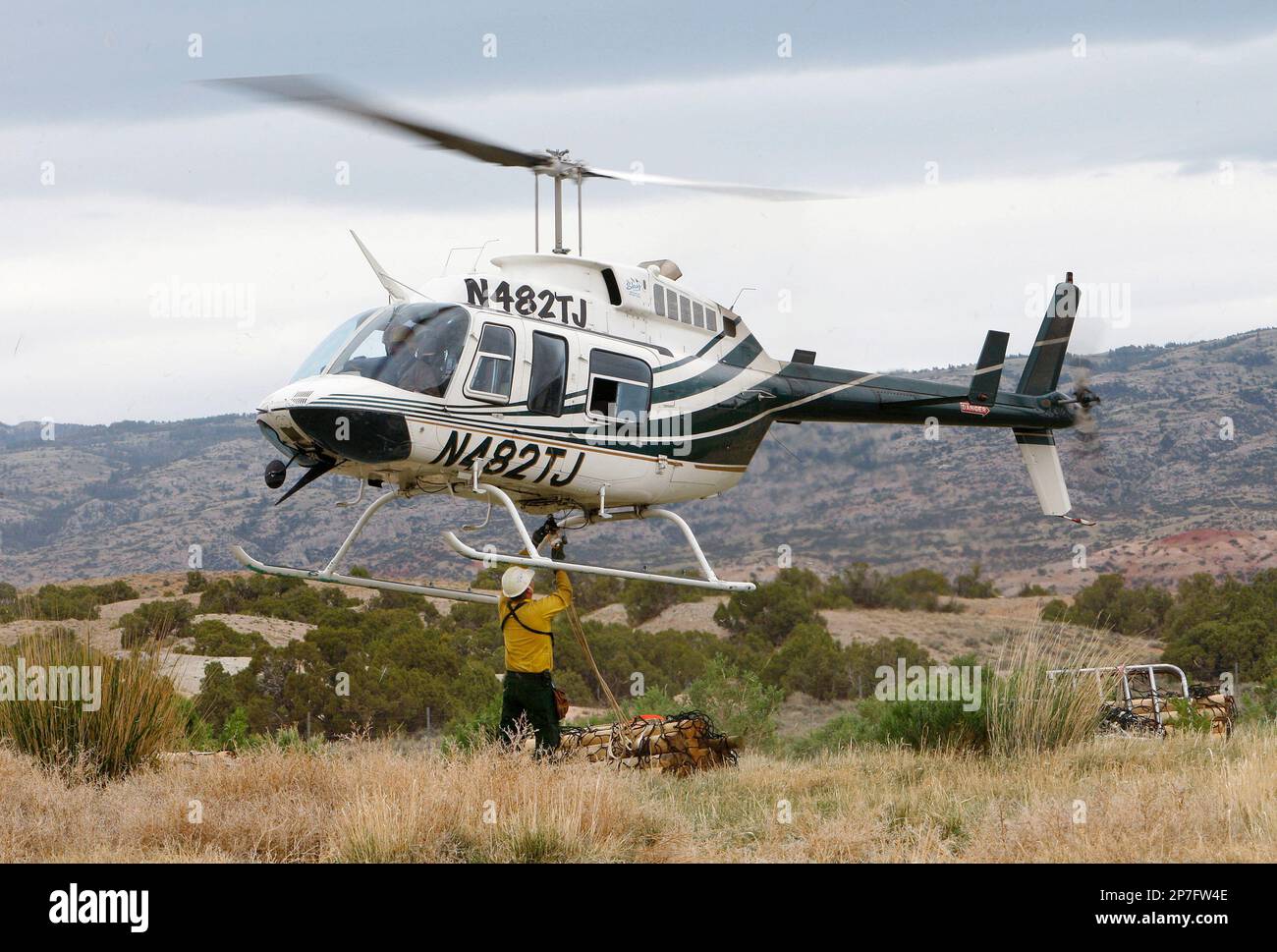 Neil Thorneycroft of the BLM's Eastern Montana Helitack crew attaches a ...