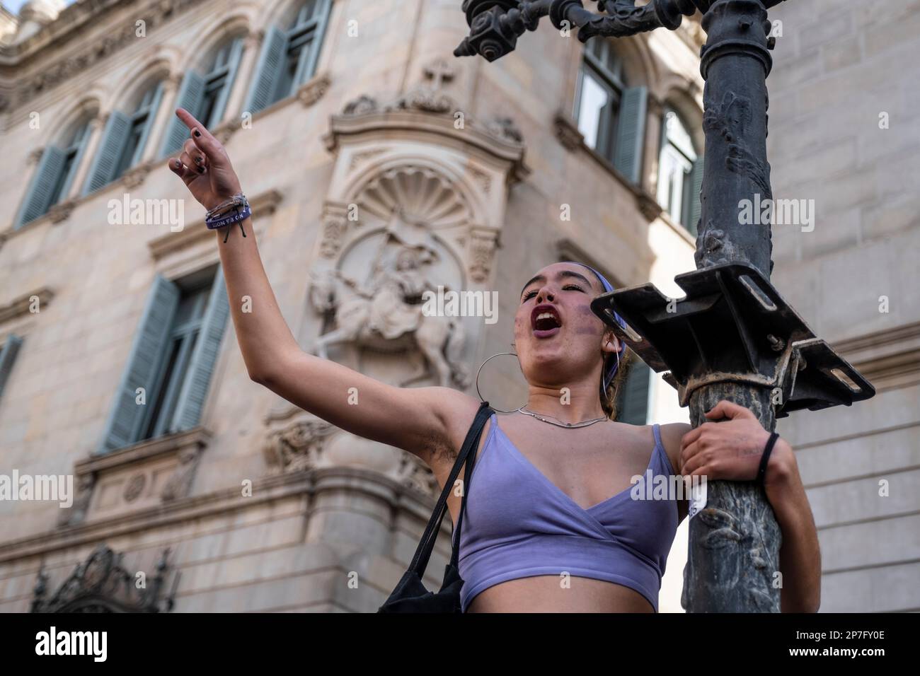 A female protester is seen shouting feminist slogans from a lamppost ...