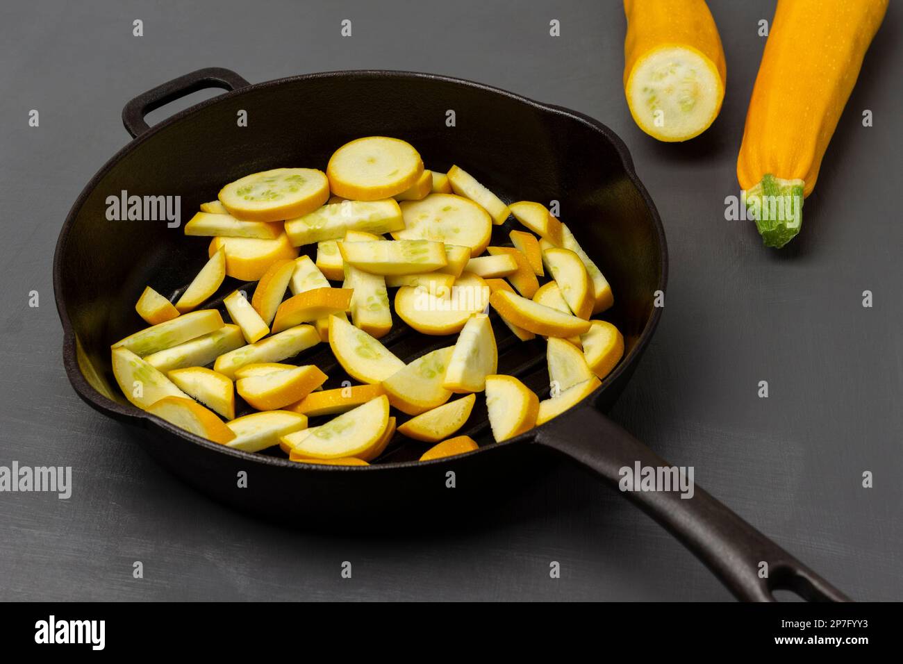 Two whole yellow zucchini. Sliced yellow zucchini in a frying pan. Top ...