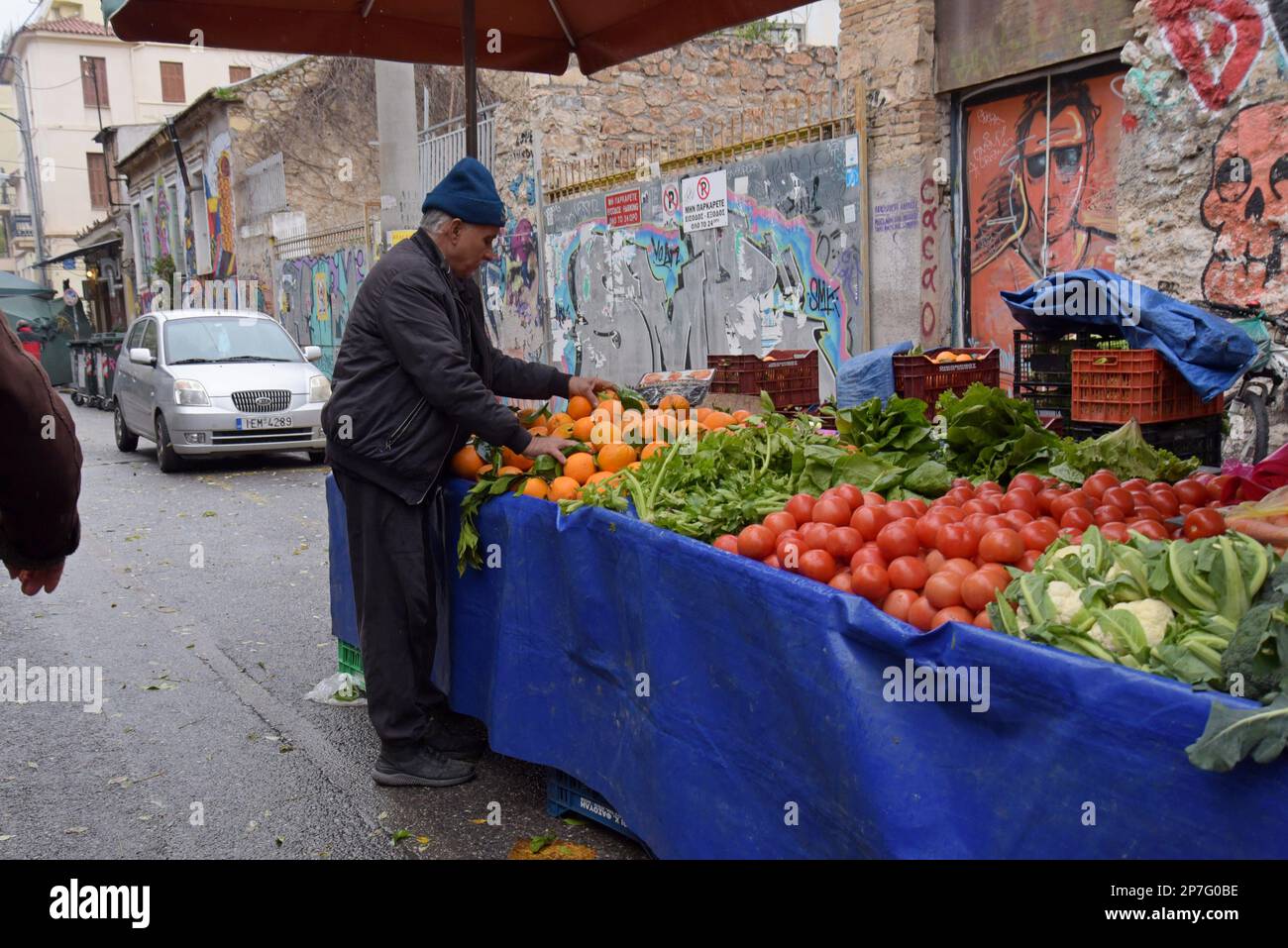 A stallholder arranging fresh produce at a traditional market in ...