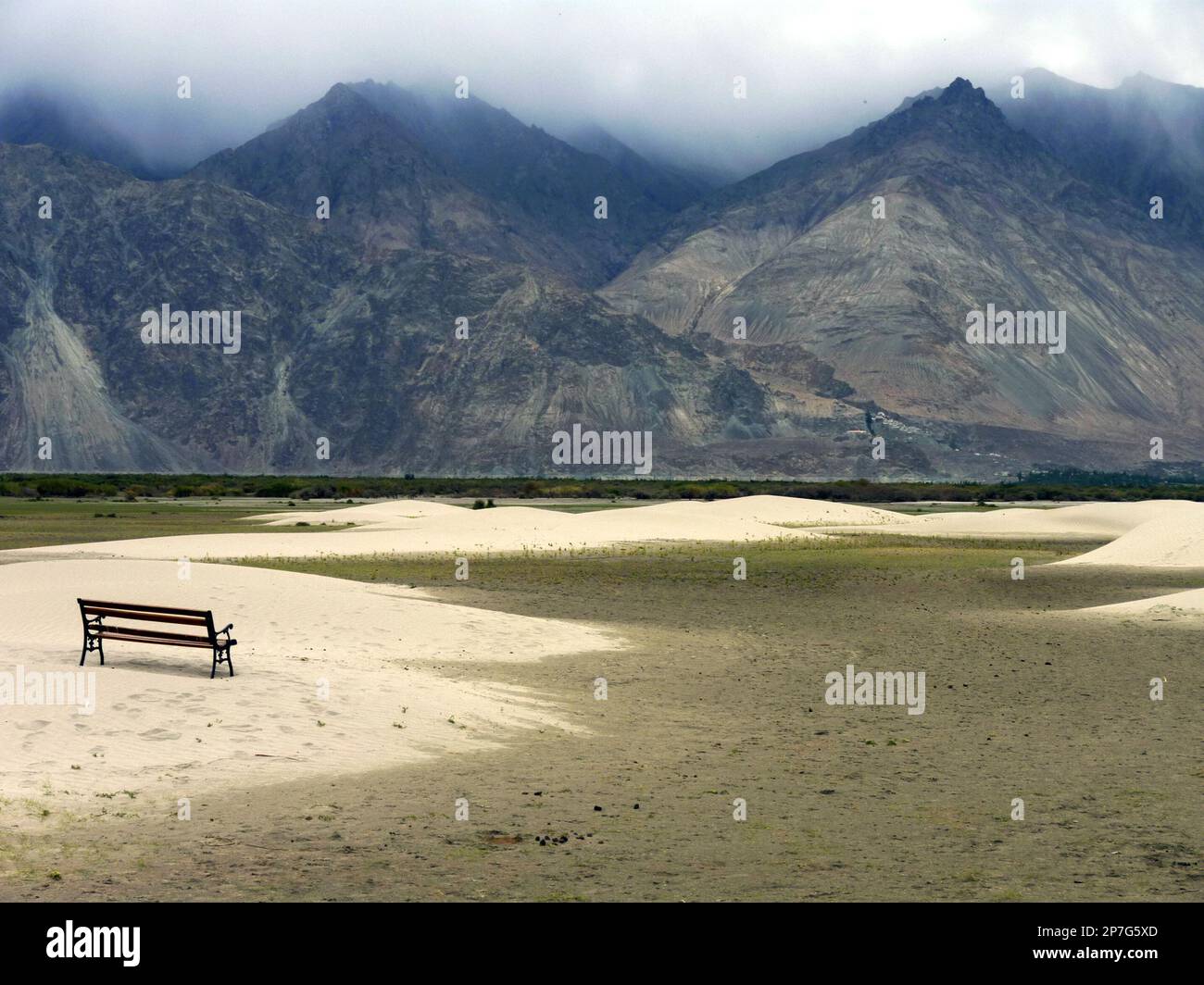Peaceful view of a bench facing the high mountains in the desert of the ...