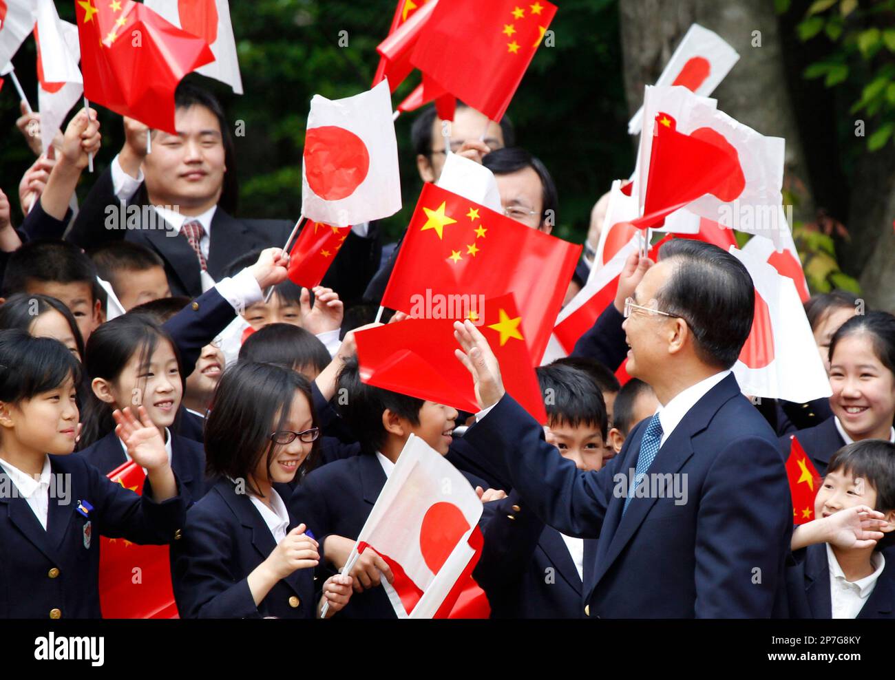 Chinese Premier Wen Jiabao waves to children during a welcoming ...