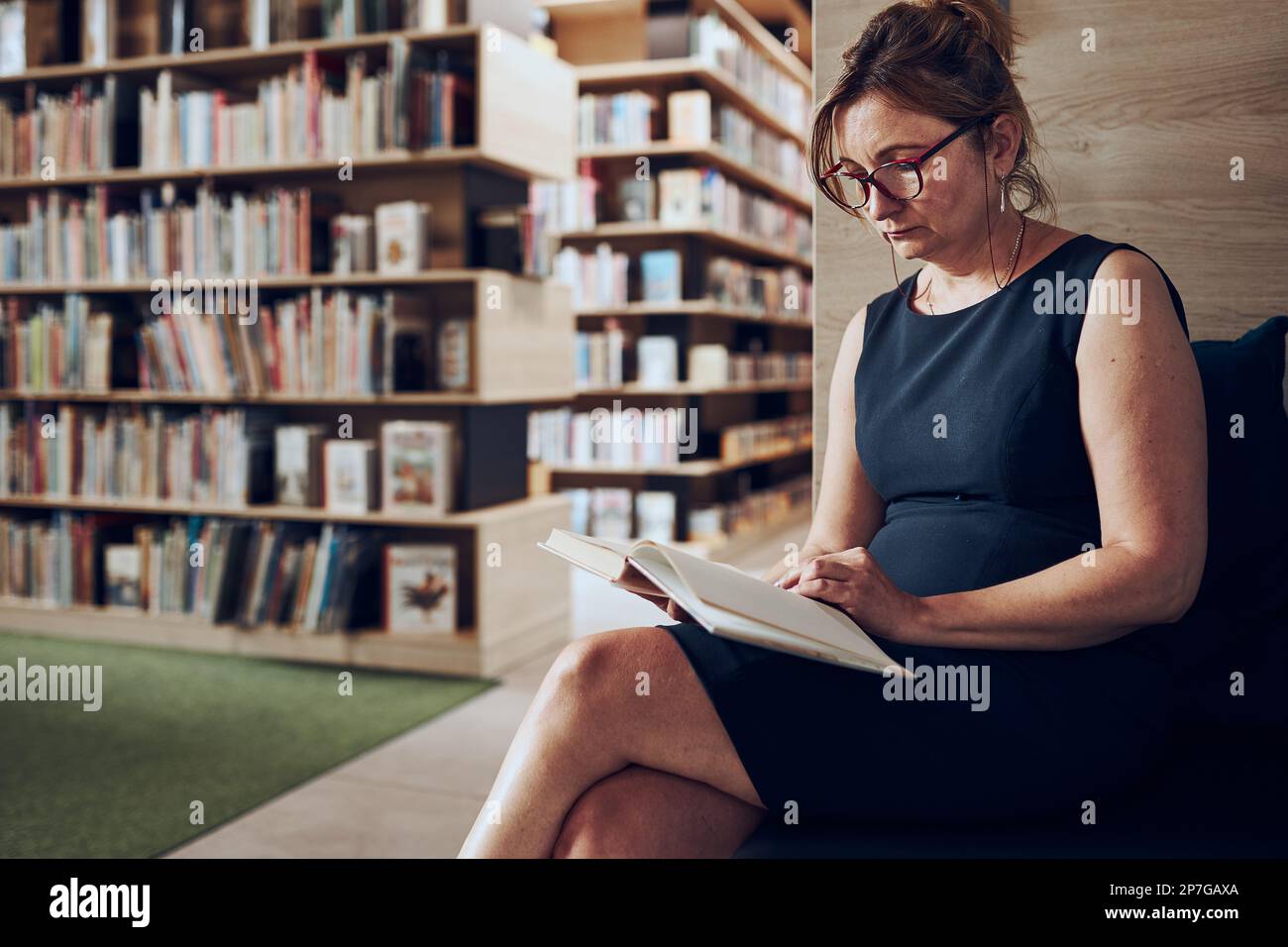 Woman reading book in public library. Searching for literature for ...
