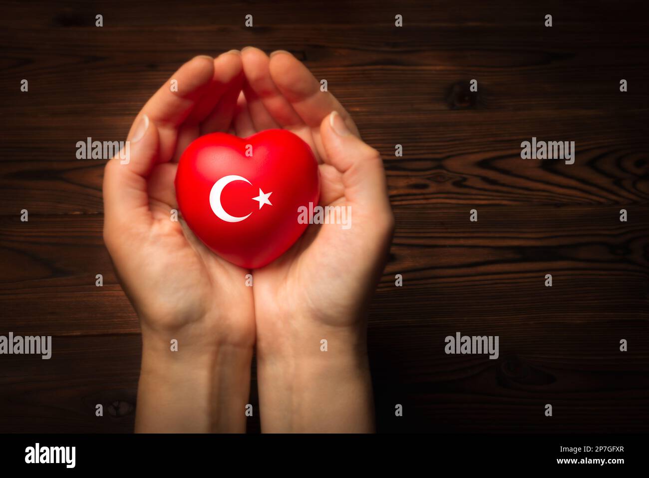 female hands hold and giving red heart in the form of a Turkey flag ...