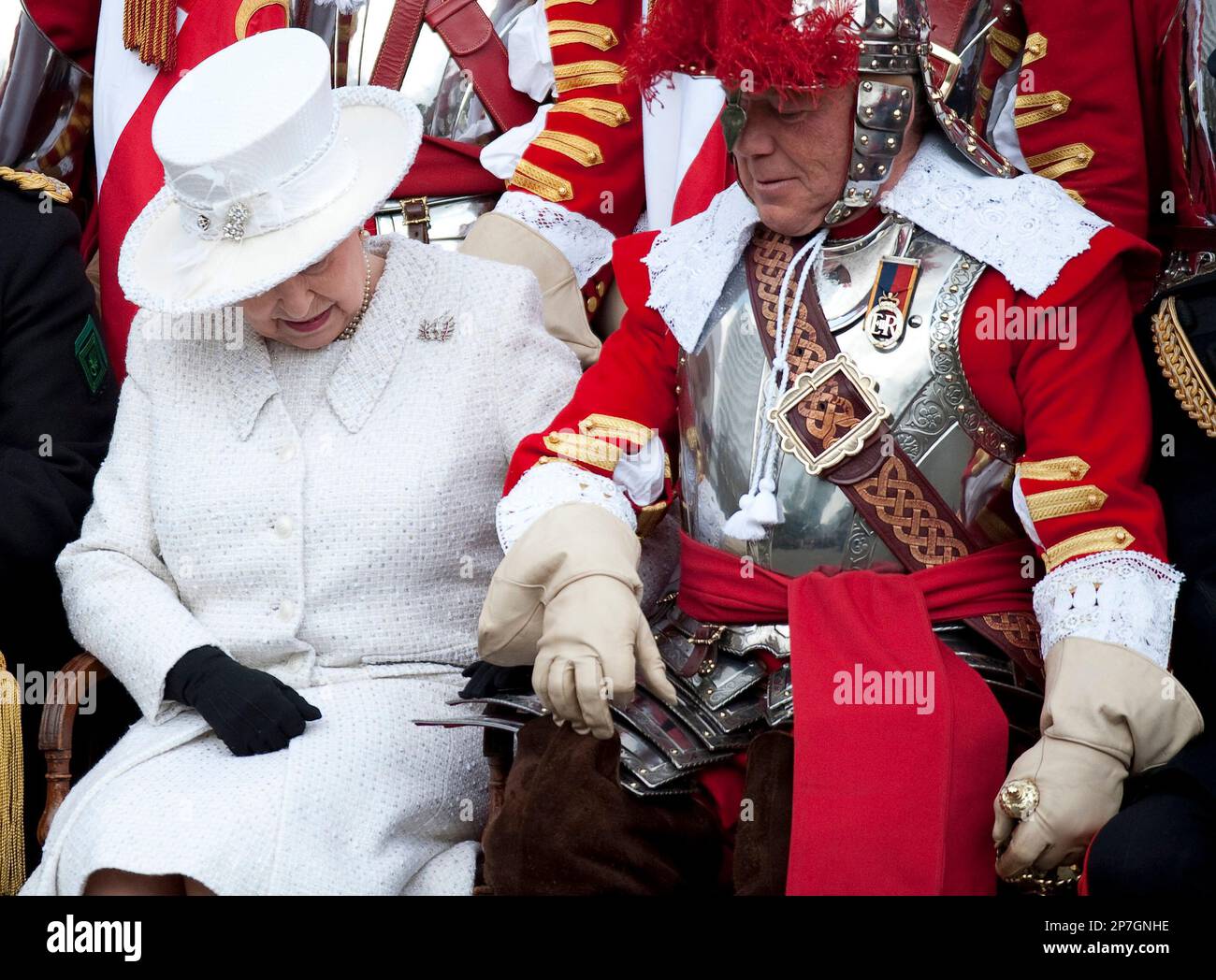 Britain's Queen Elizabeth II becomes entangled in the armour of Major ...
