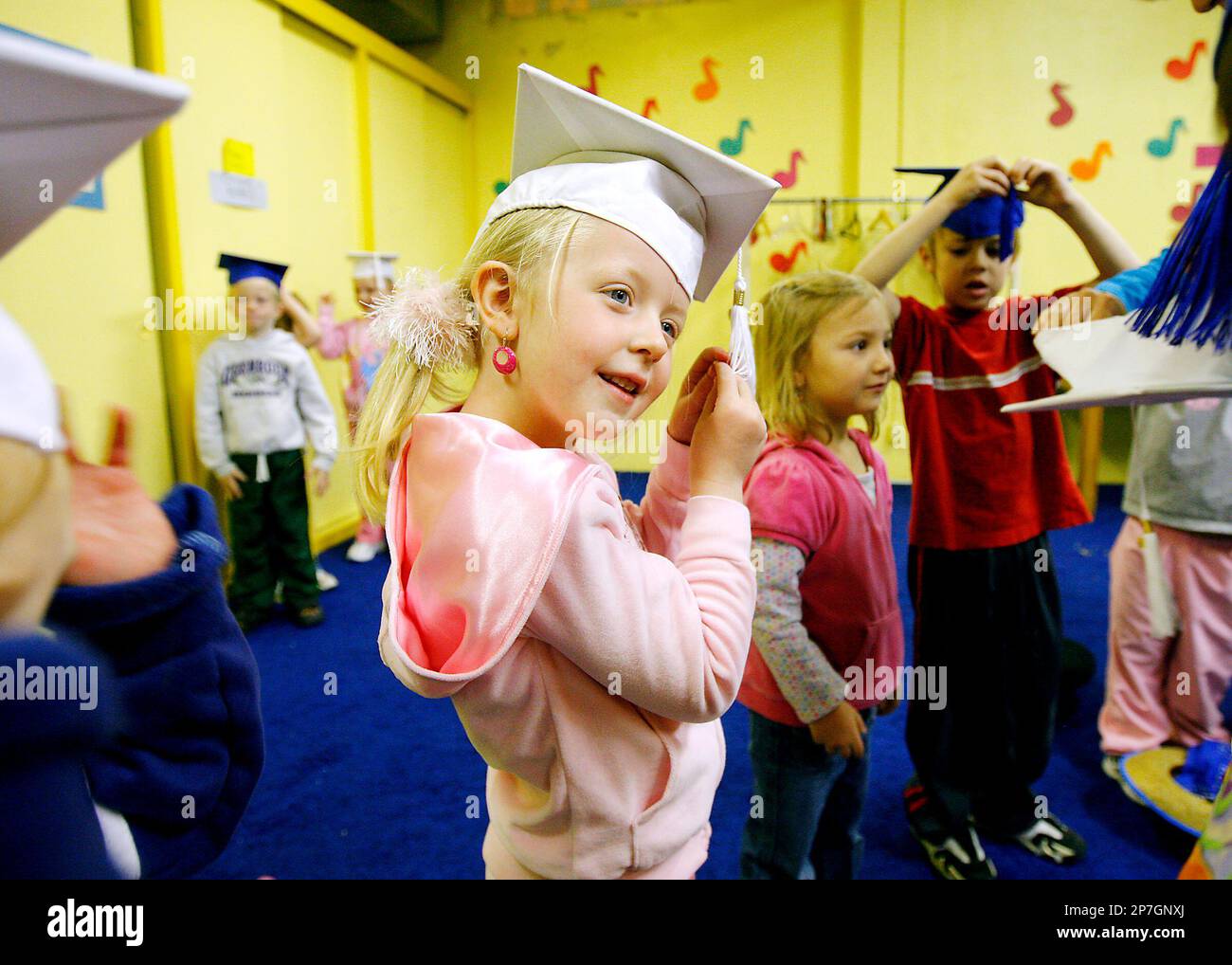 Chloe Bowden, 5, tries on her graduation cap during rehearsals for the ...