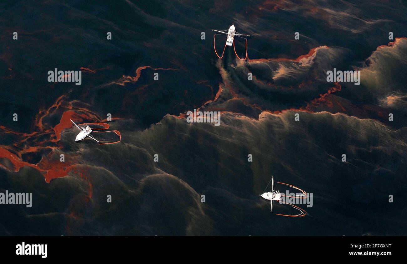 Shrimp boats are used to collect oil with booms in the waters of ...