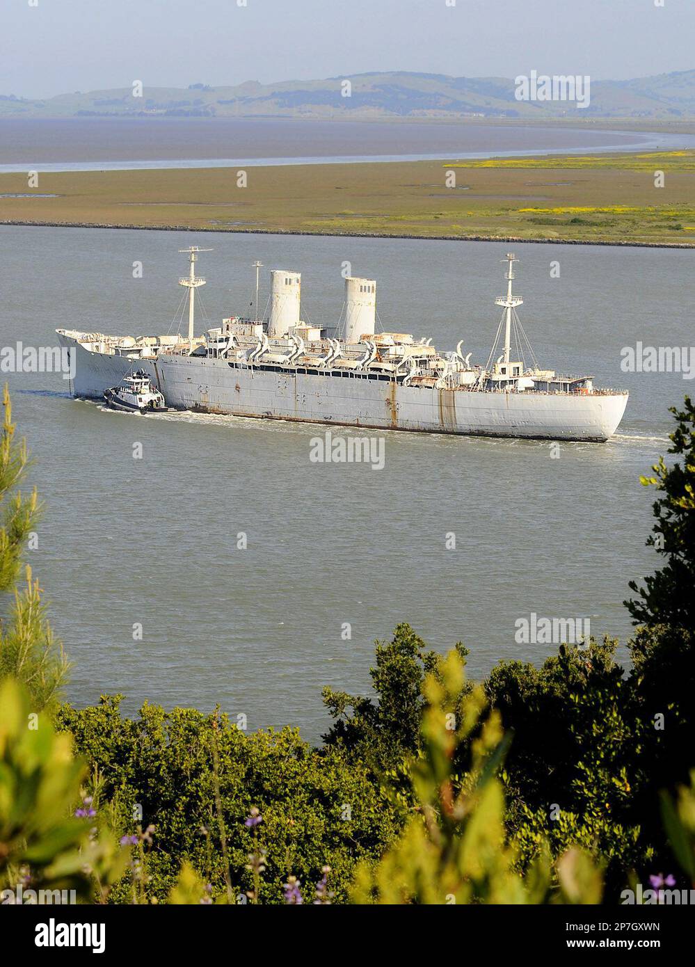 Tug boats guide the USS General John Pope into the San Pablo Bay north ...