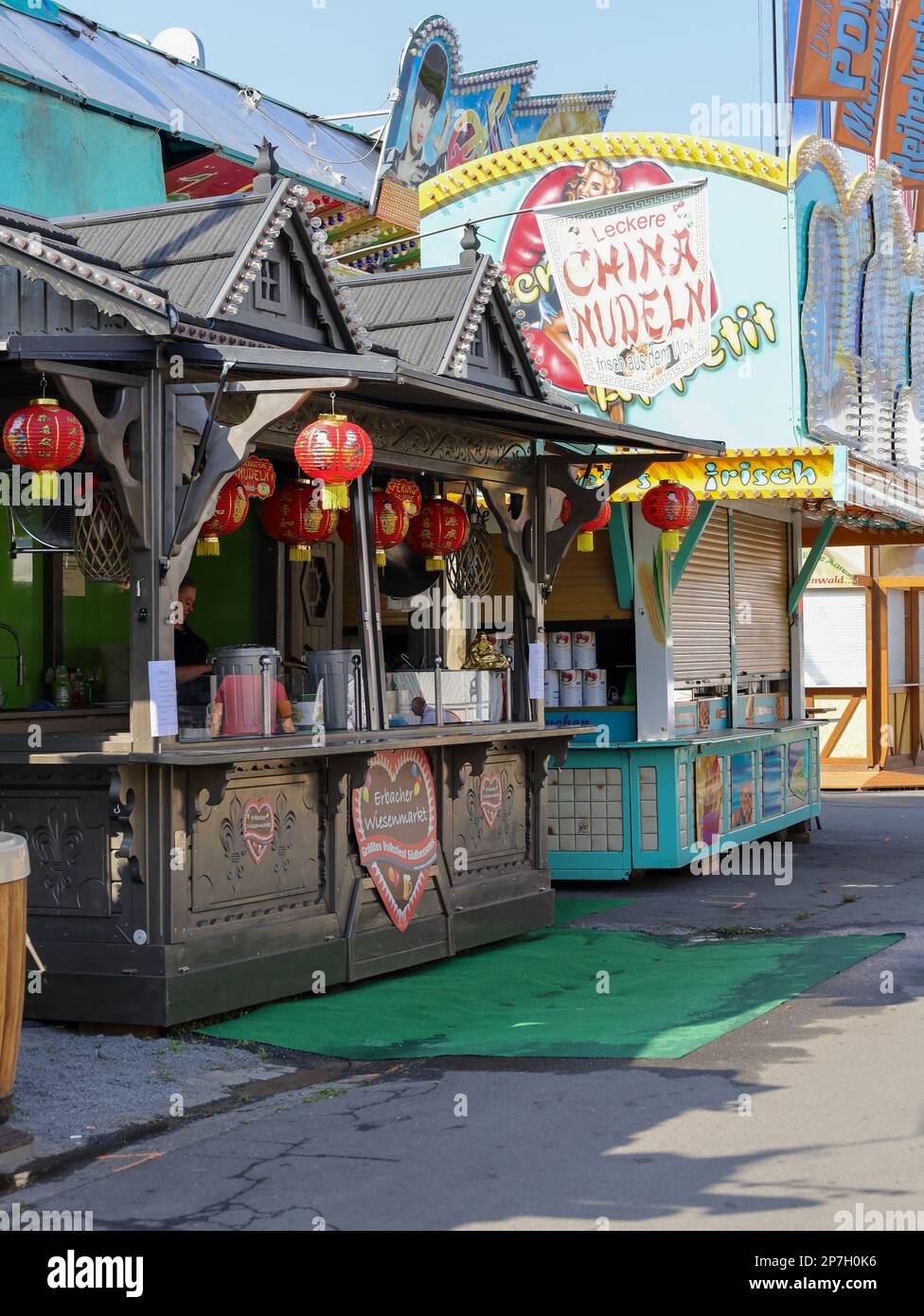 colorful booths and fun rides at a fairground Stock Photo - Alamy