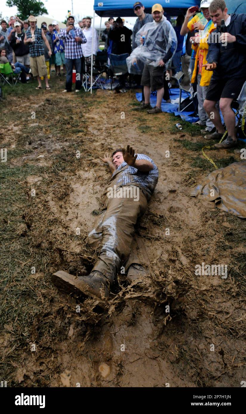 A spectator slides in the mud in the infield before the 136th Kentucky ...
