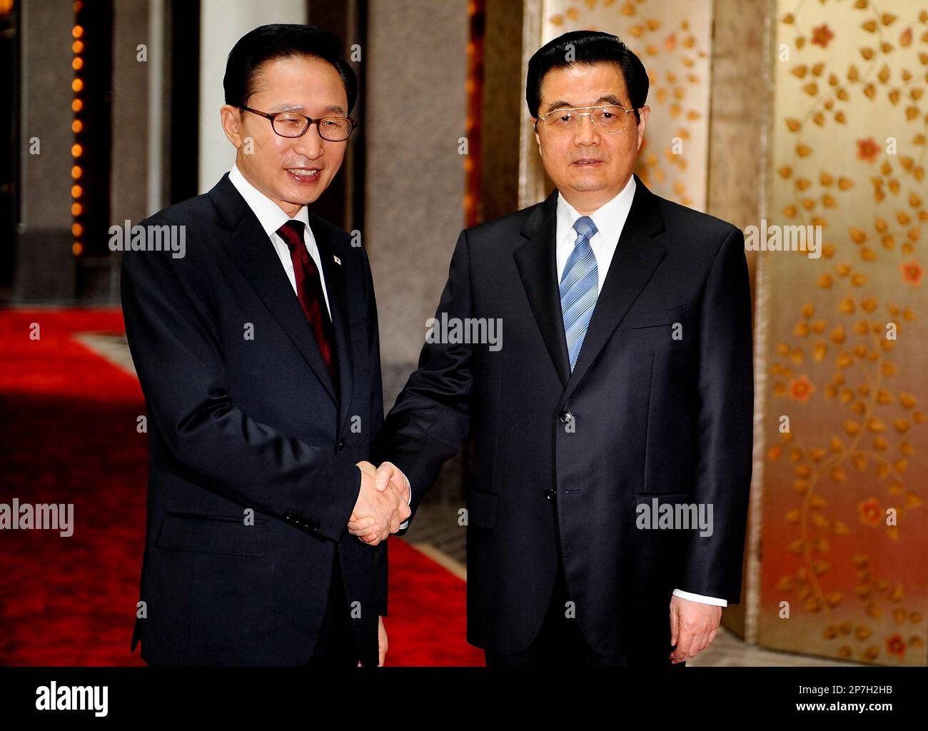 Chinese President Hu Jintao (R) shakes hands with South Korean ...