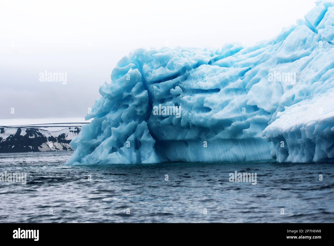 Bergy bit - part of iceberg. Ship sails in immediate vicinity. Arctic ...