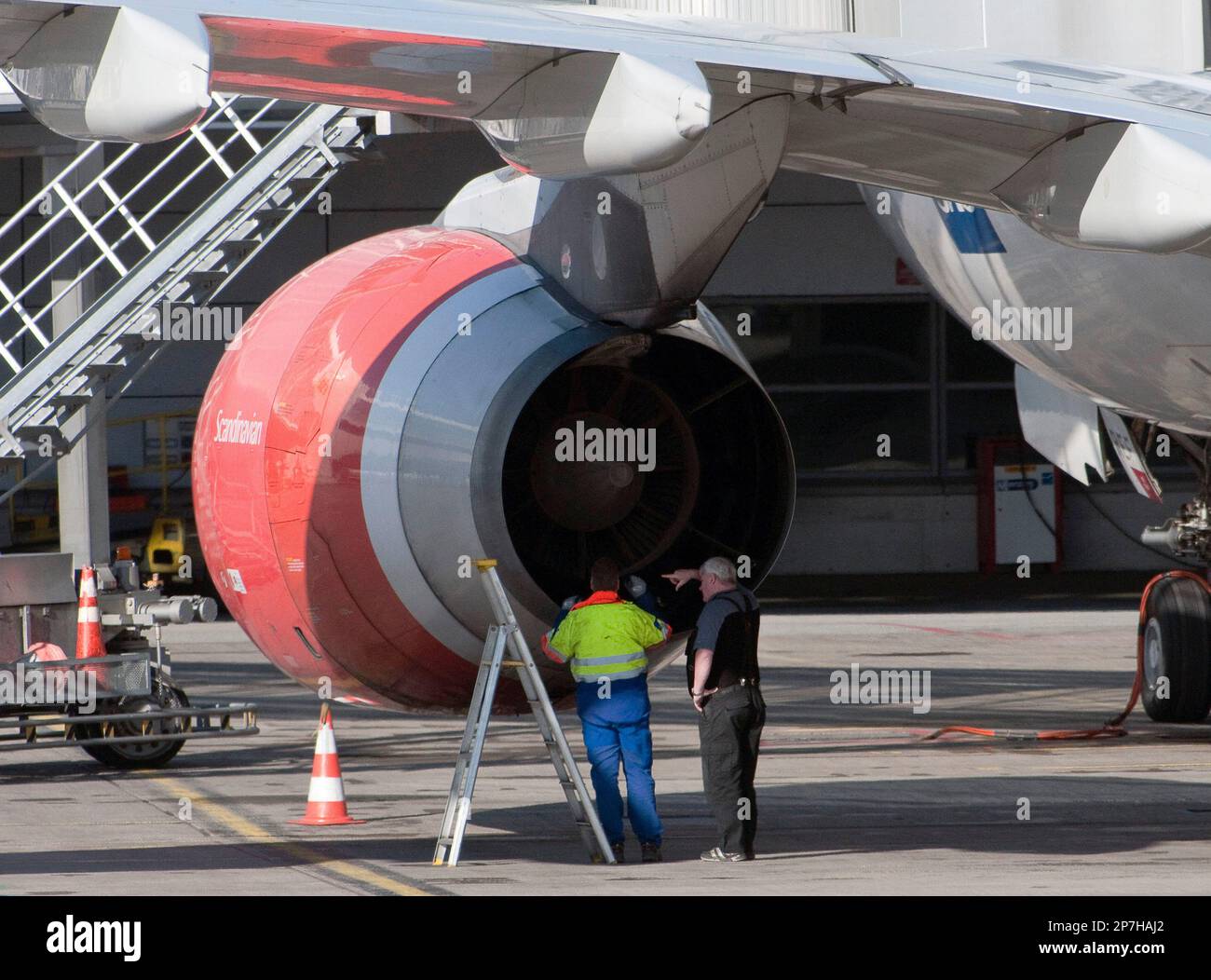 Technicians check the jet engine of a Scandinavian Airlines for ...