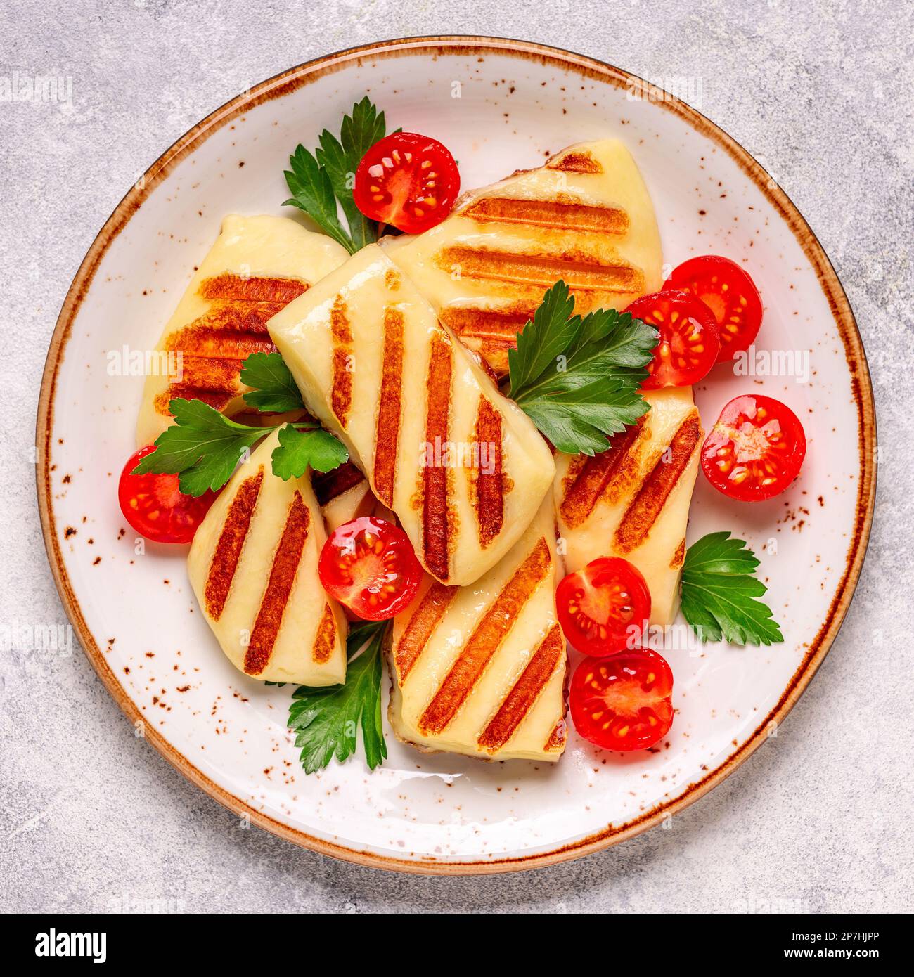 Grilled halloumi cheese served with tomatoes and parsley Stock Photo ...