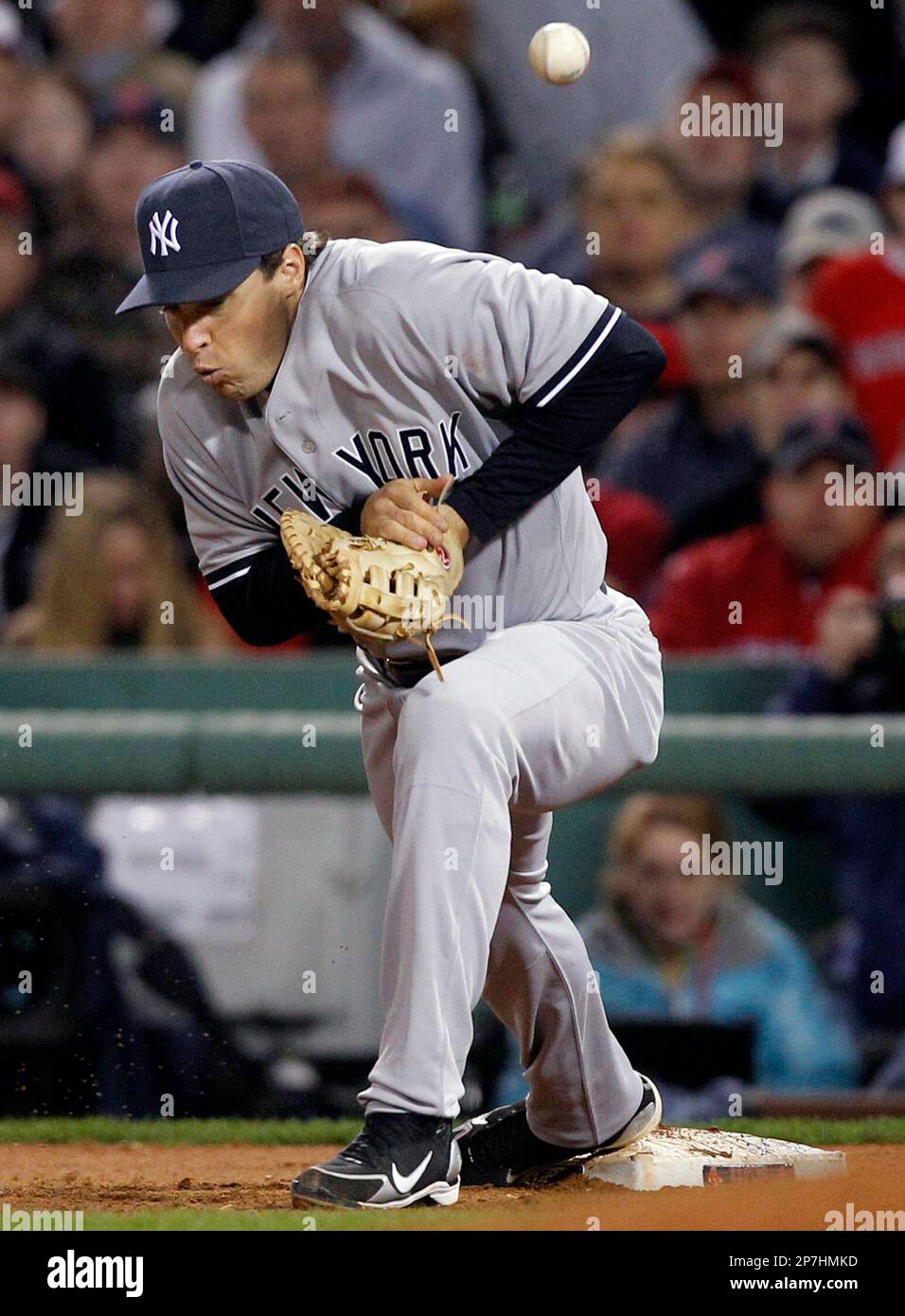 New York Yankees first baseman Mark Teixeira cannot handle an errant ...