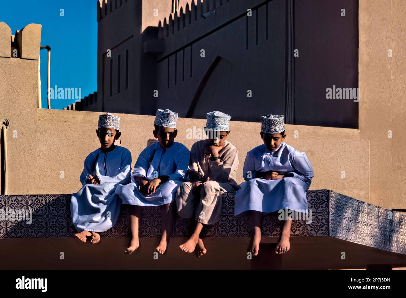 Boys with kuma hats on the roof, Nizwa, Oman Stock Photo - Alamy