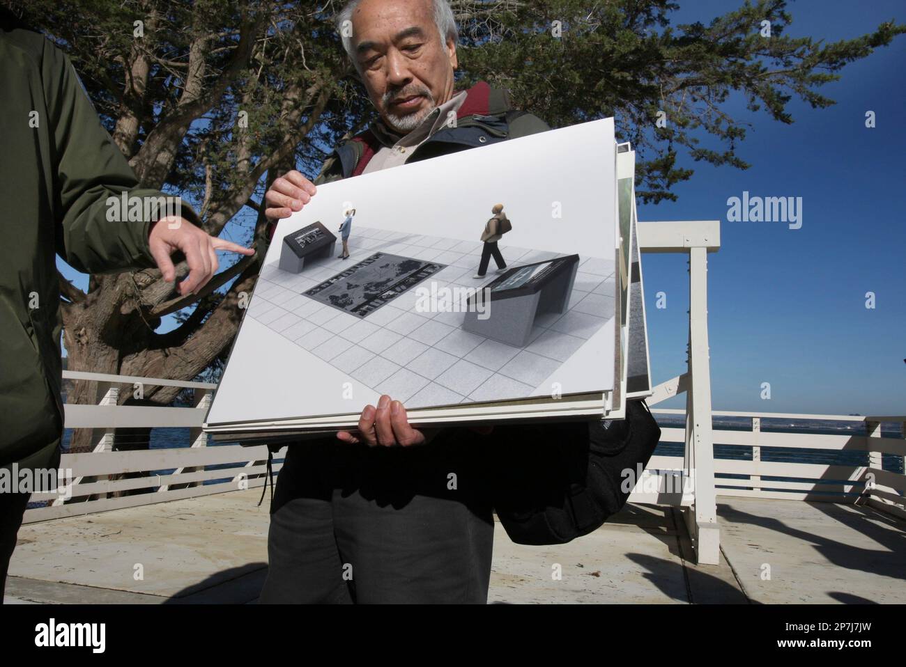 Interpretive Designer, Daniel Quan, holds an artist rendition of what ...