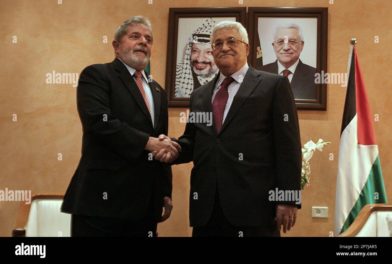 Palestinian President Mahmoud Abbas, right, shakes hands with his ...