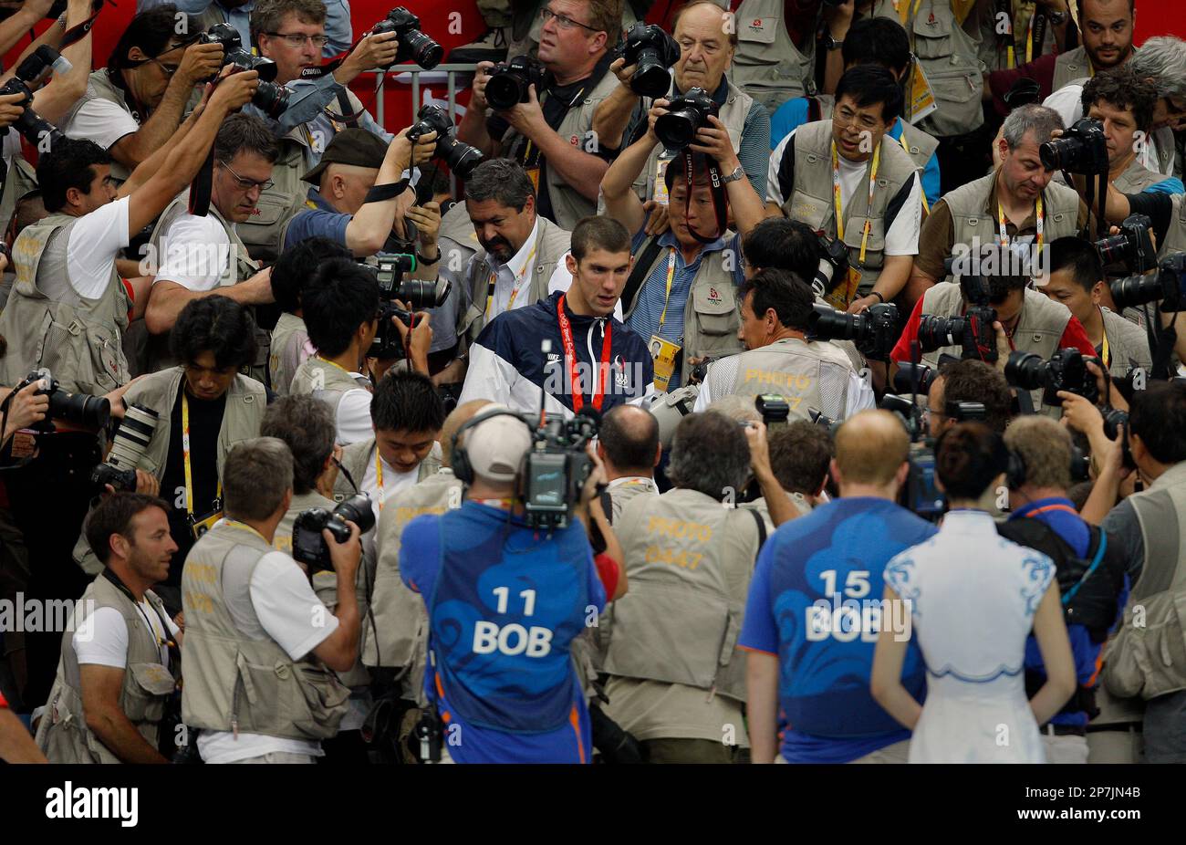 Michael Phelps navigates his way through a cluster of media after the ...