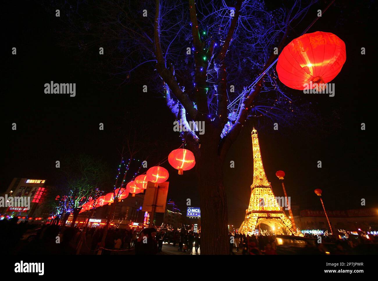 Visitors admire a huge lantern set of the Eiffel Tower during a lantern ...