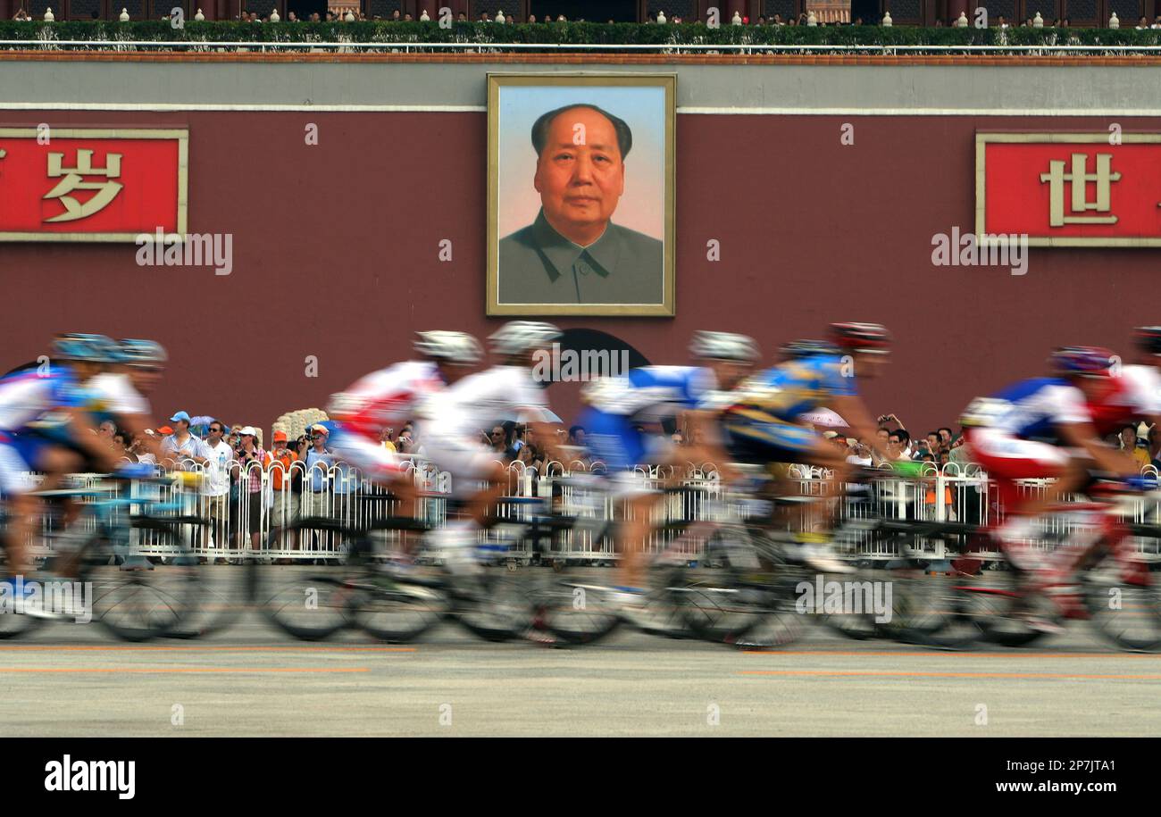 Road Cycling riders race past the portrait of Mao Zedong in front of ...