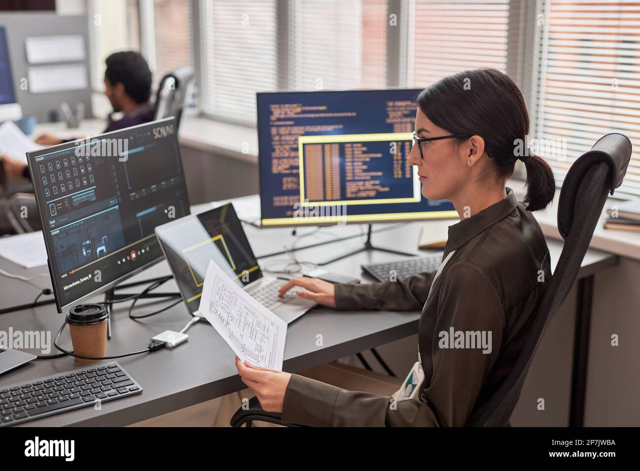 Side view portrait of female data engineer working with computers at ...