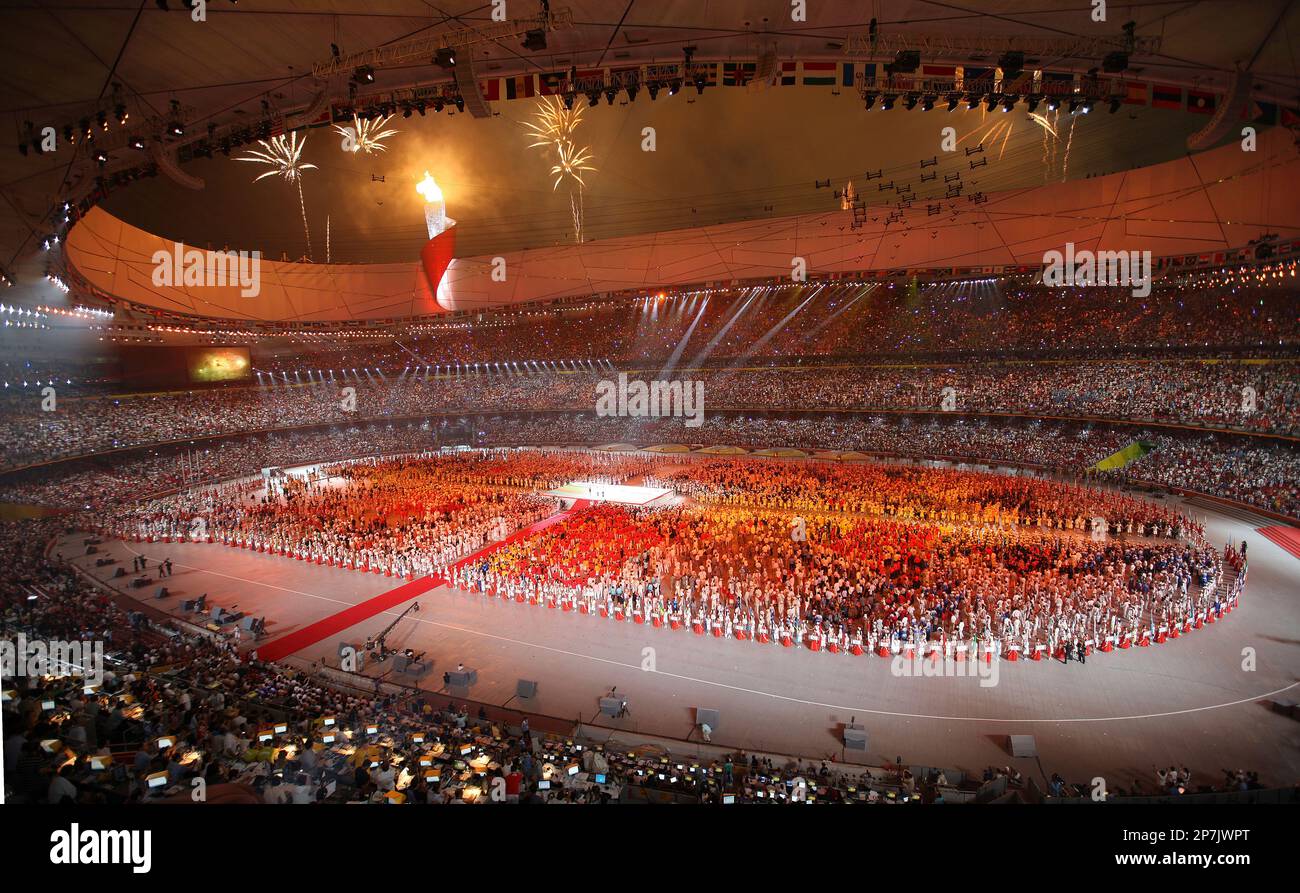 The Olympic torch glows inside the National Outdoor Stadium, filled ...