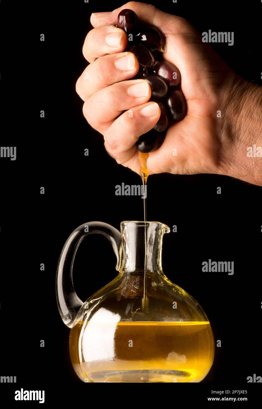 hand is squeezing the olive oil Stock Photo - Alamy