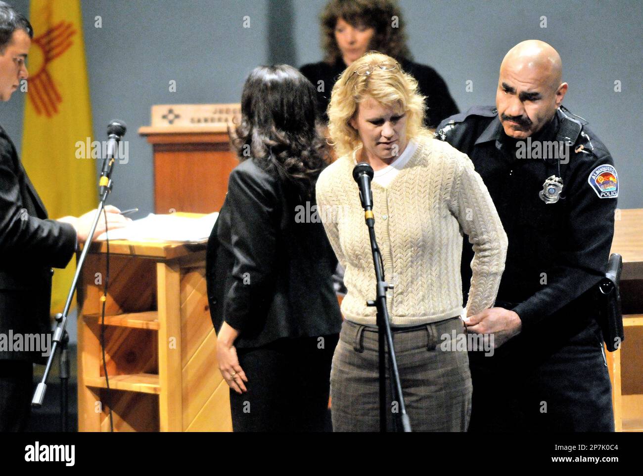 Albuquerque Police officer Mike Davis, right, handcuffs Ann Luevano, a ...