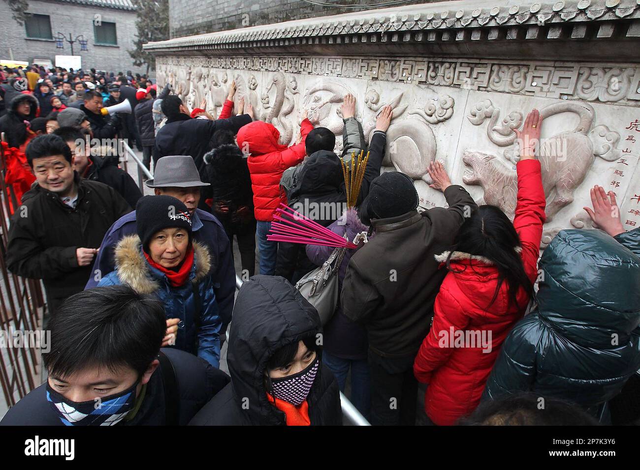 Pepole touch the stone tiger at the Baiyun Guan to get blessing on the ...