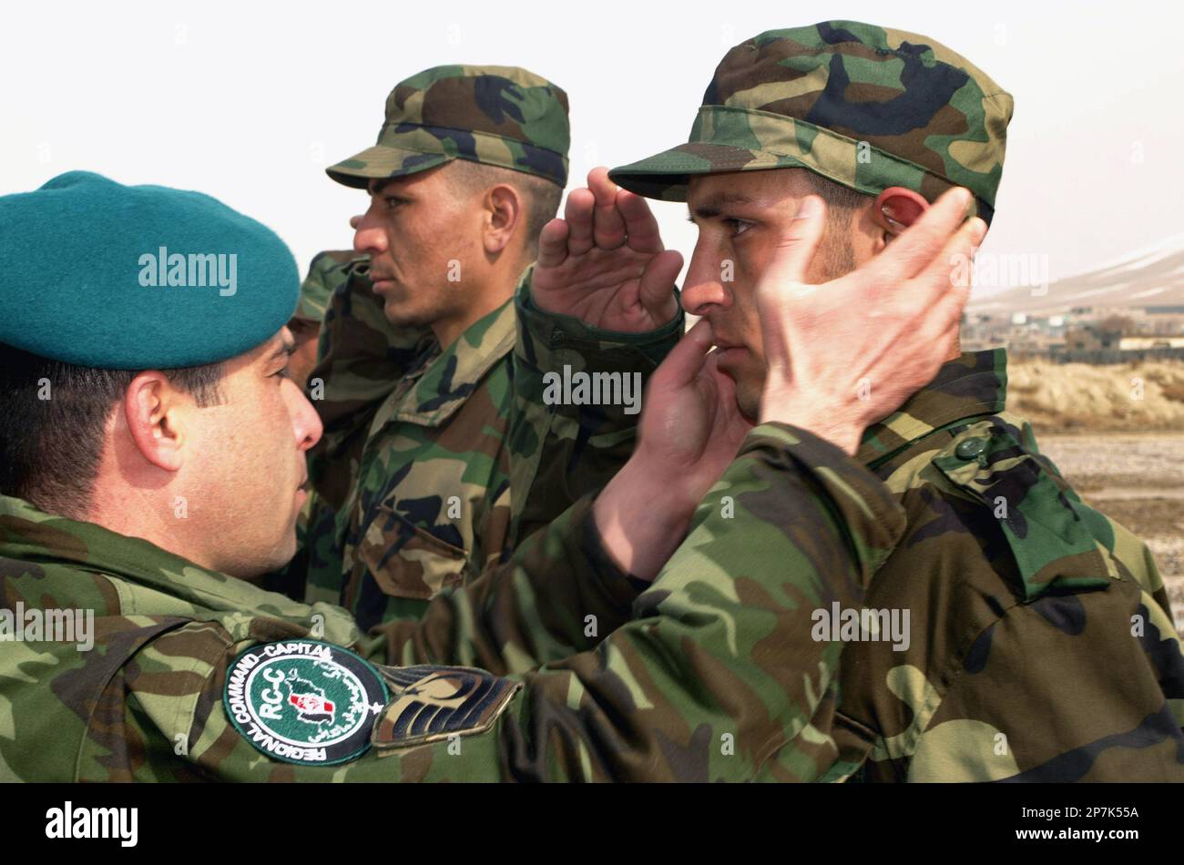 A Turkish sergeant straightens the head of an Afghan soldier as he ...