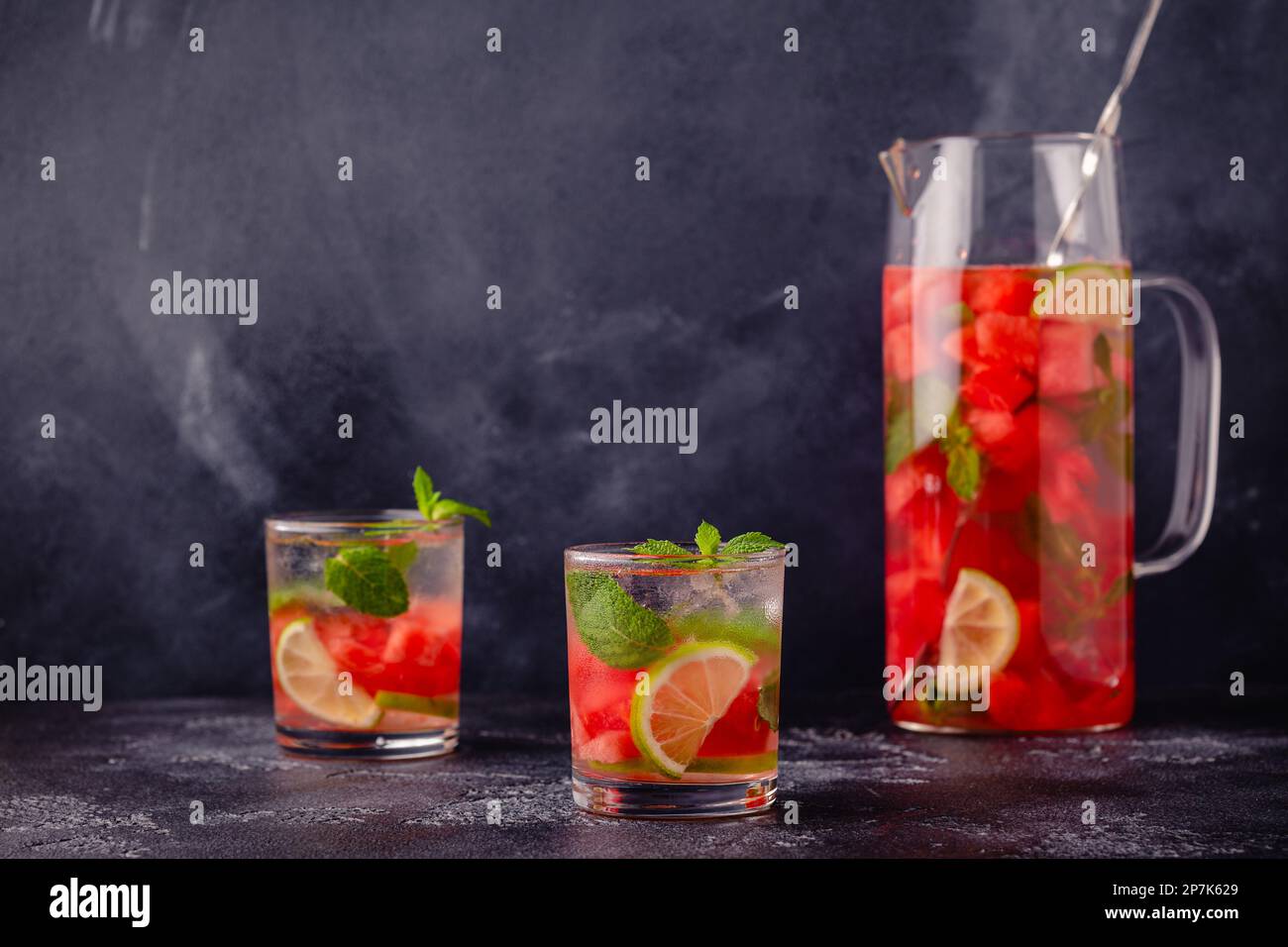 Watermelon infusion water with lime and mint in a jug and glasses Stock ...