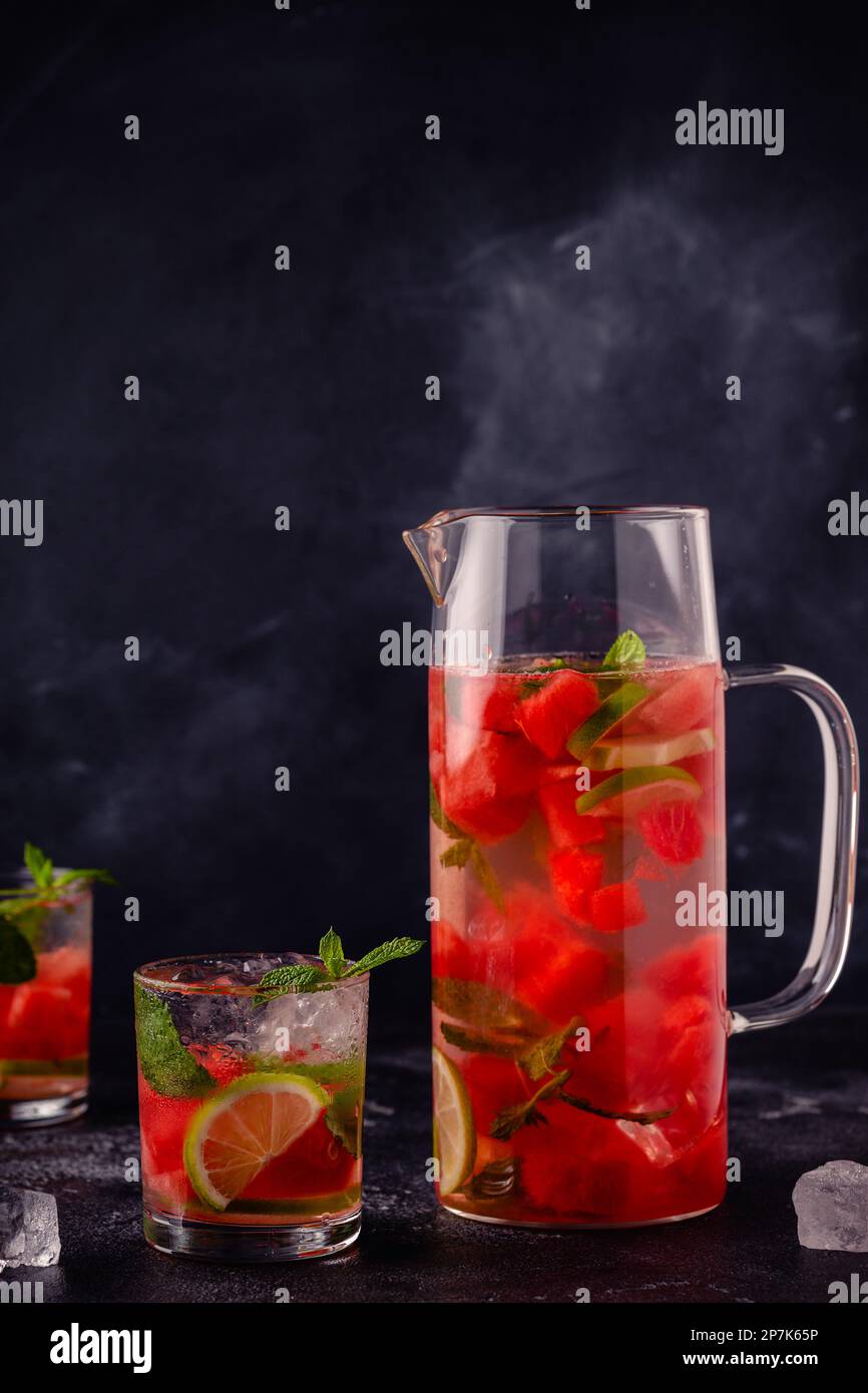 Watermelon infusion water with lime and mint in a jug and glasses Stock ...