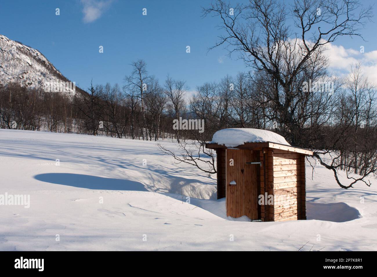 Small hidden restroom partly covered under deep, newly fallen snow ...