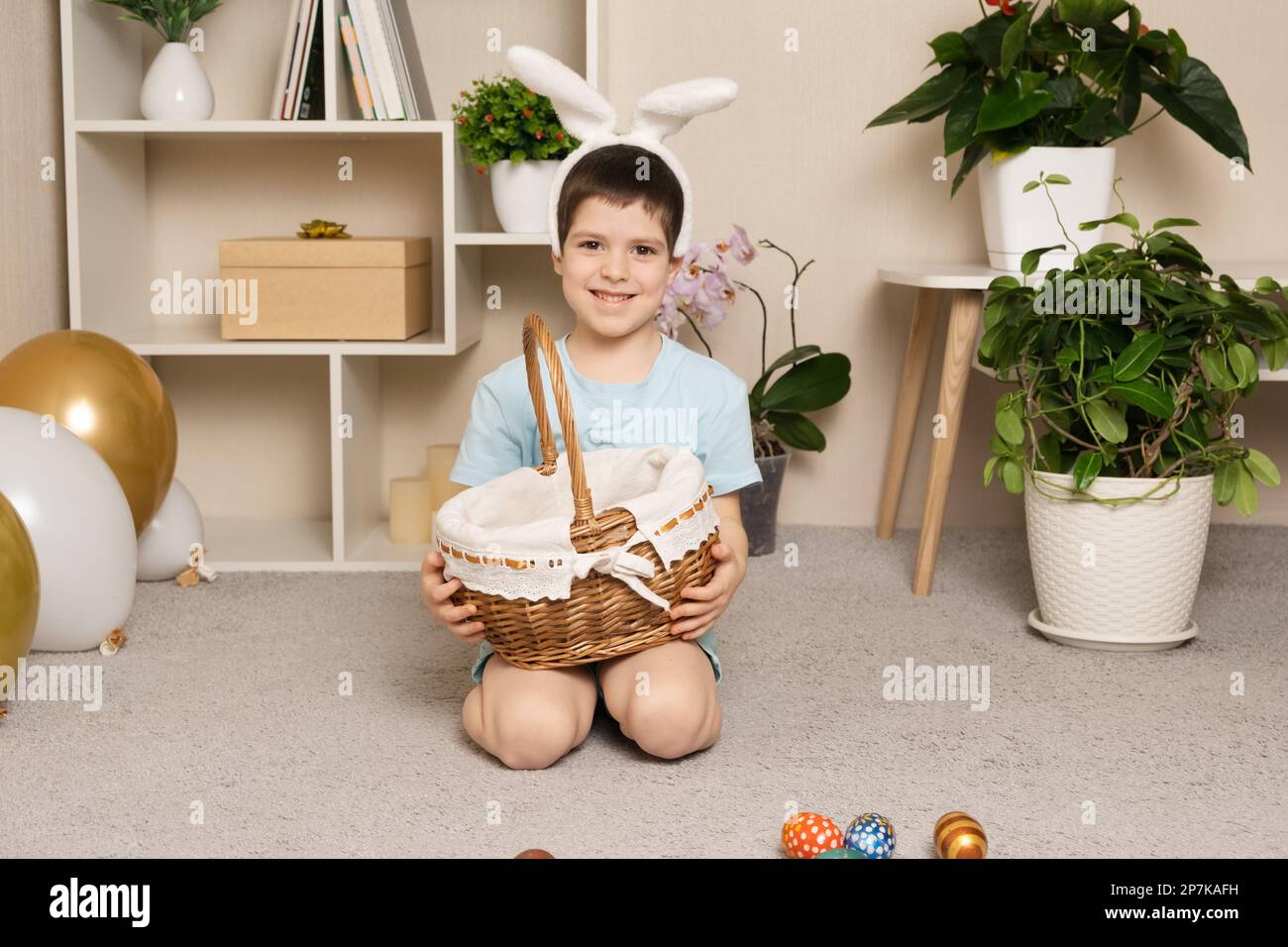 Easter Child - Preschool boy with rabbit ears on his head plays with a ...