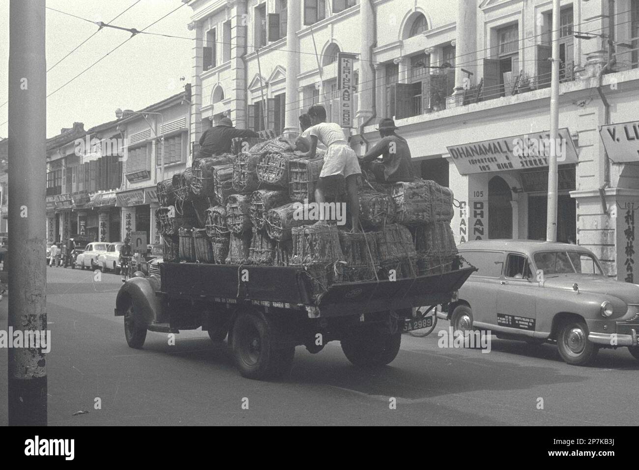 Overloaded lorry, on 7 May, 1956, a common sight in Singapore ...