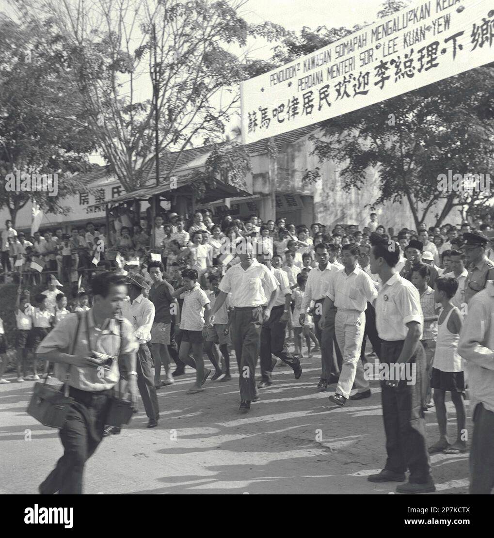 Prime Minister Lee Kuan Yew (centre) on another of his rural tours of Singapore, this time to ...
