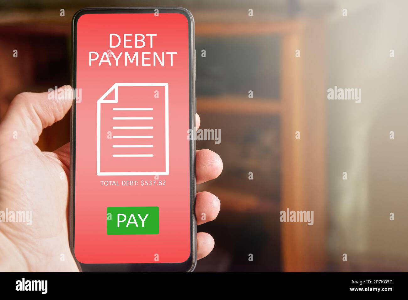 Man holding mobile phone with debt payment app interface on the screen ...