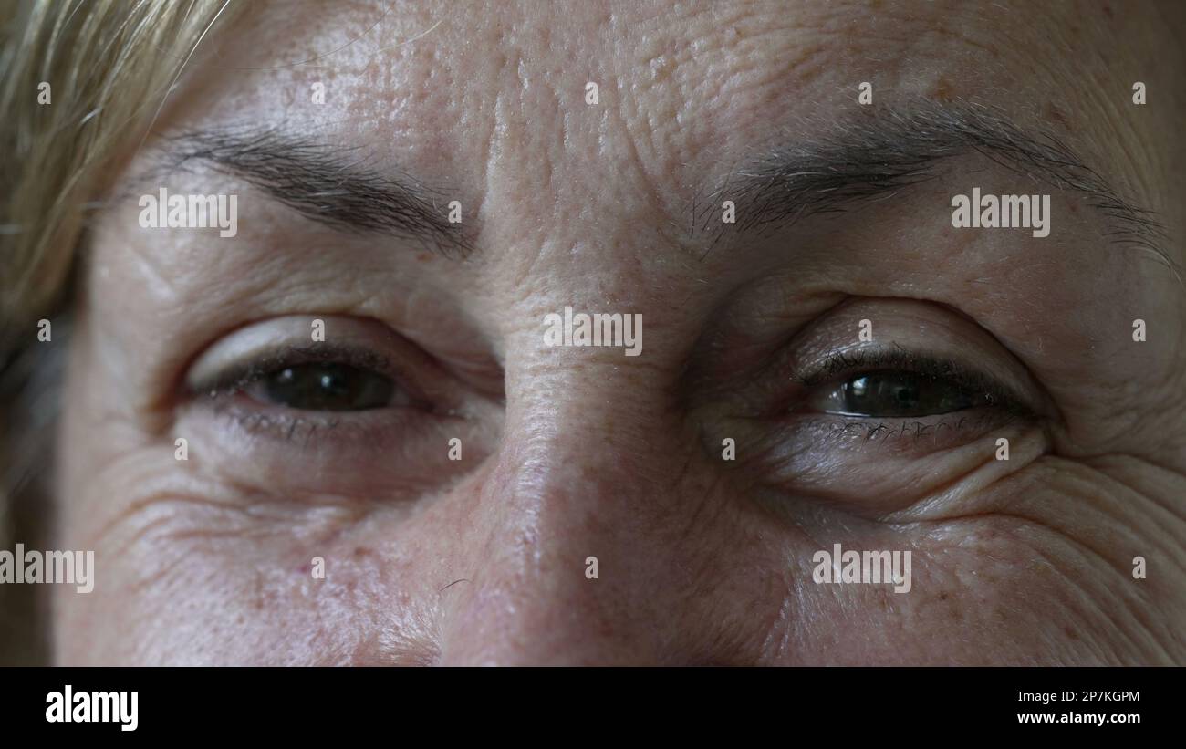 Senior woman opening eyes macro closeup. Portrait face detail of mature ...