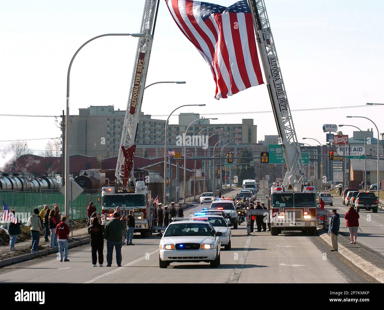 The funeral procession of Marine Staff Sgt. Matt Ingham drives under a ...