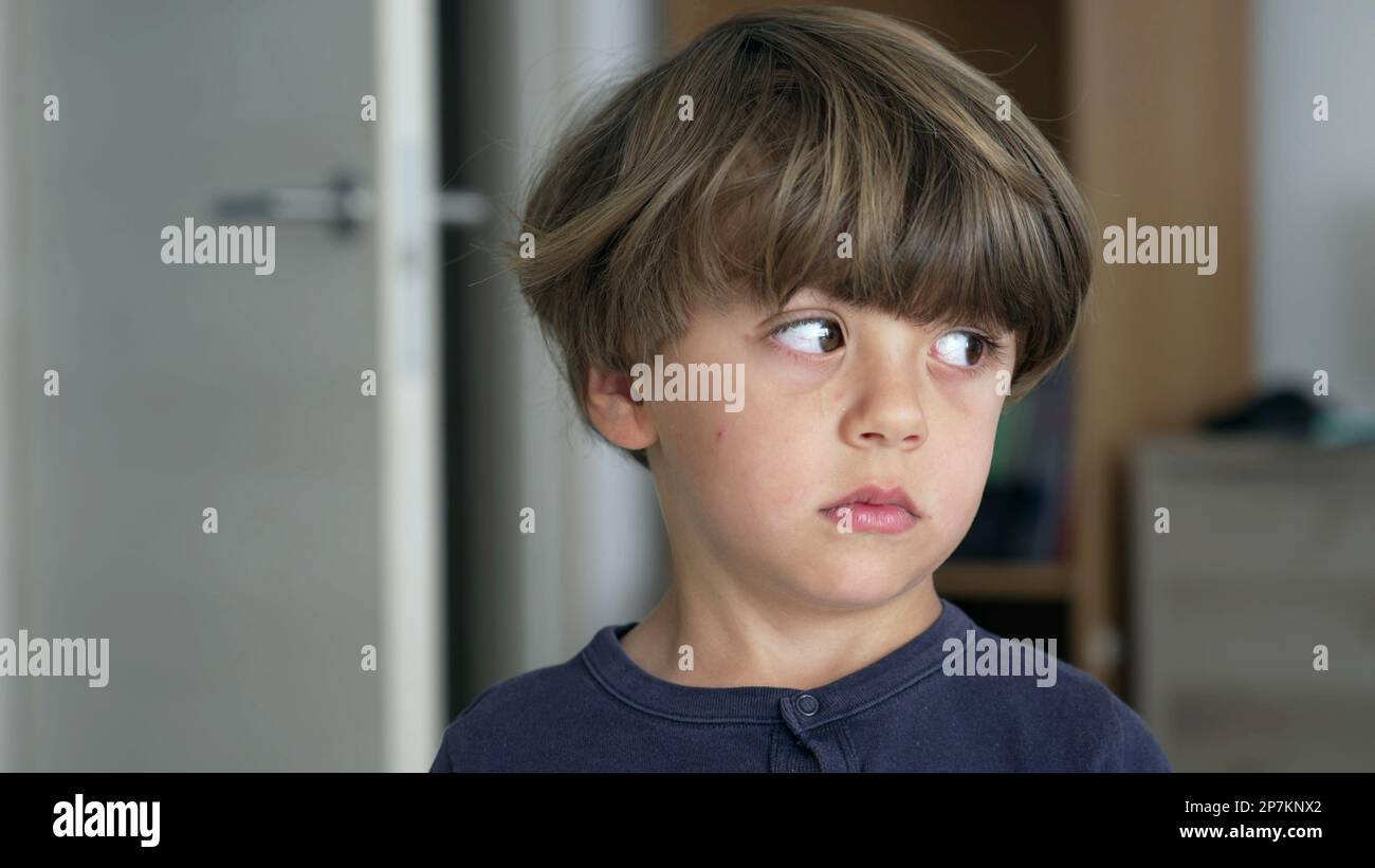 Portrait of one pensive young boy looking sideways thinking. Close up ...