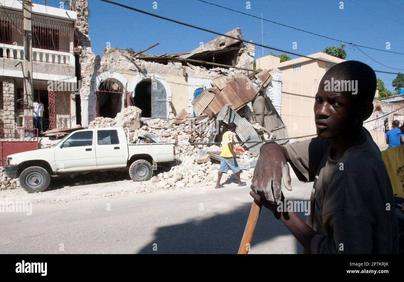 A man takes a break from clearing rubble from a damaged house in Jacmel ...