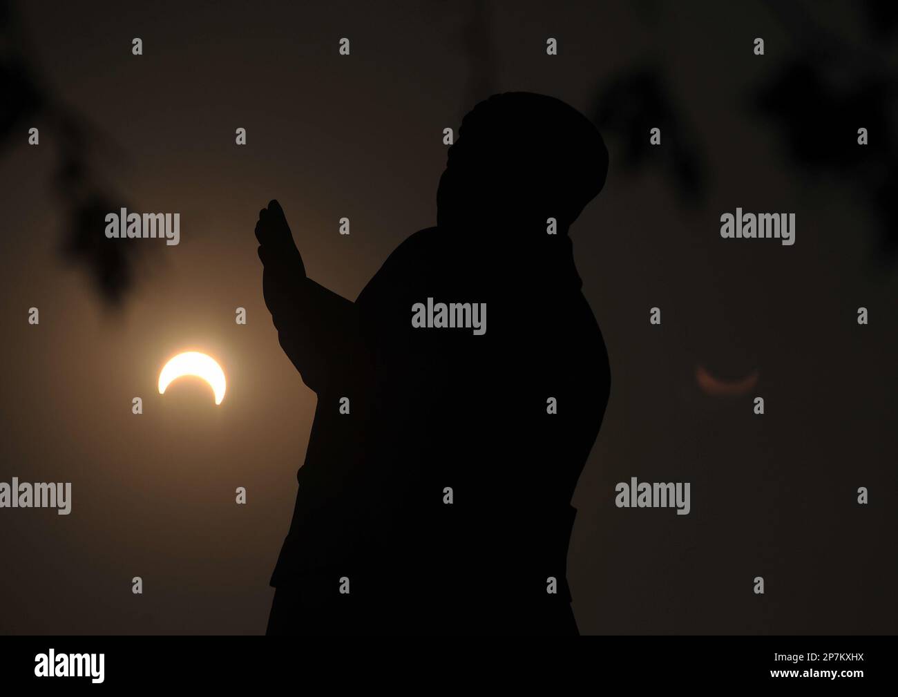 The solar eclipse is seen behind a statue of late Chinese leader Mao ...