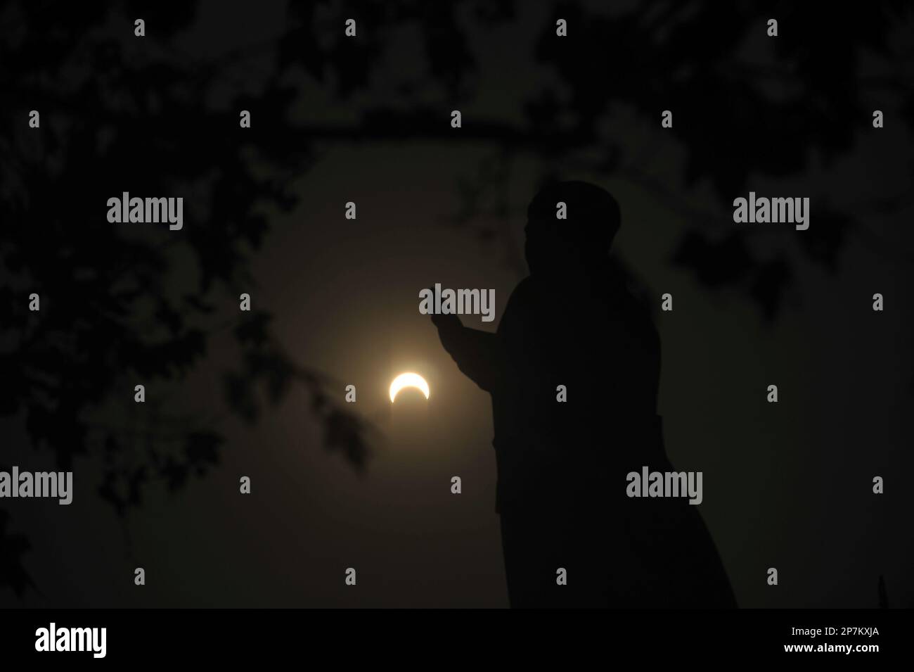 The solar eclipse is seen behind a statue of late Chinese leader Mao ...