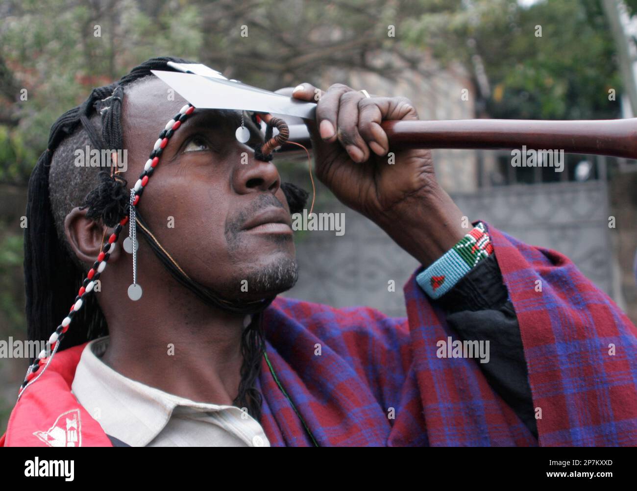A Kenyan Maasai tribesman watches a solar eclipse through a x ray film ...